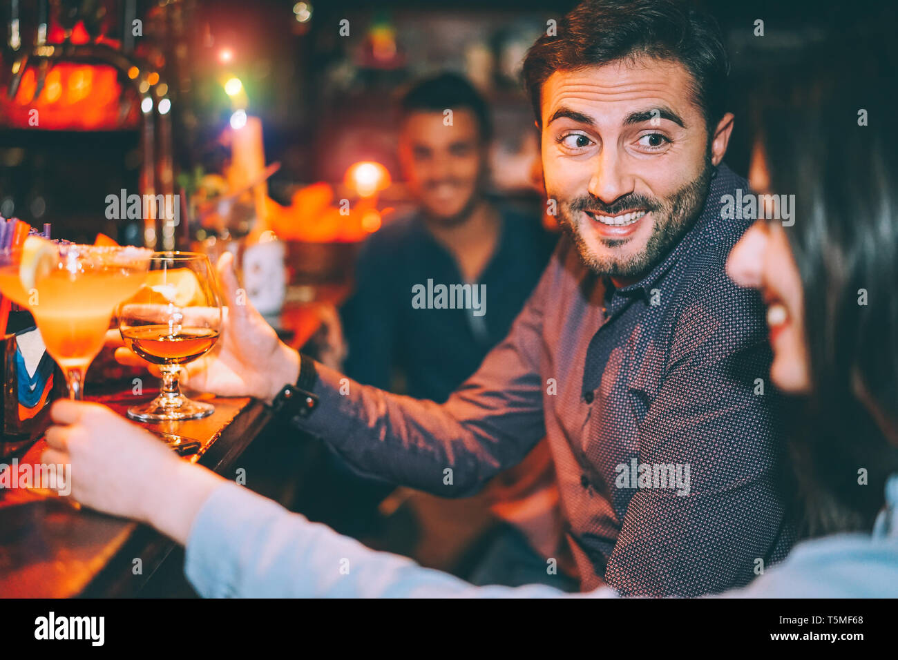 Happy friends having fun at cocktail bar - Young trendy people drinking ...