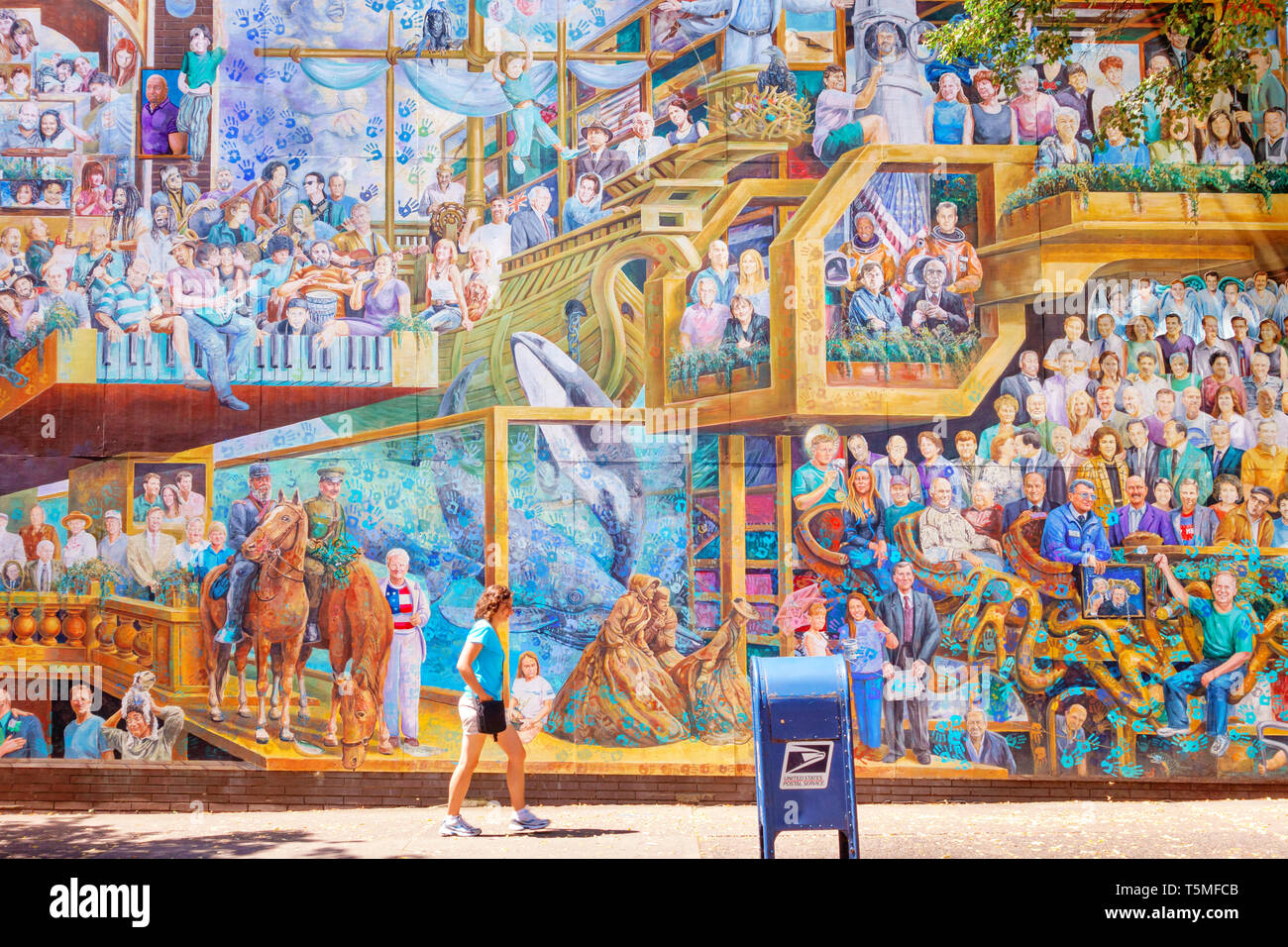 Woman walks past a mural in downtown State College, Pennsylvania, USA ...