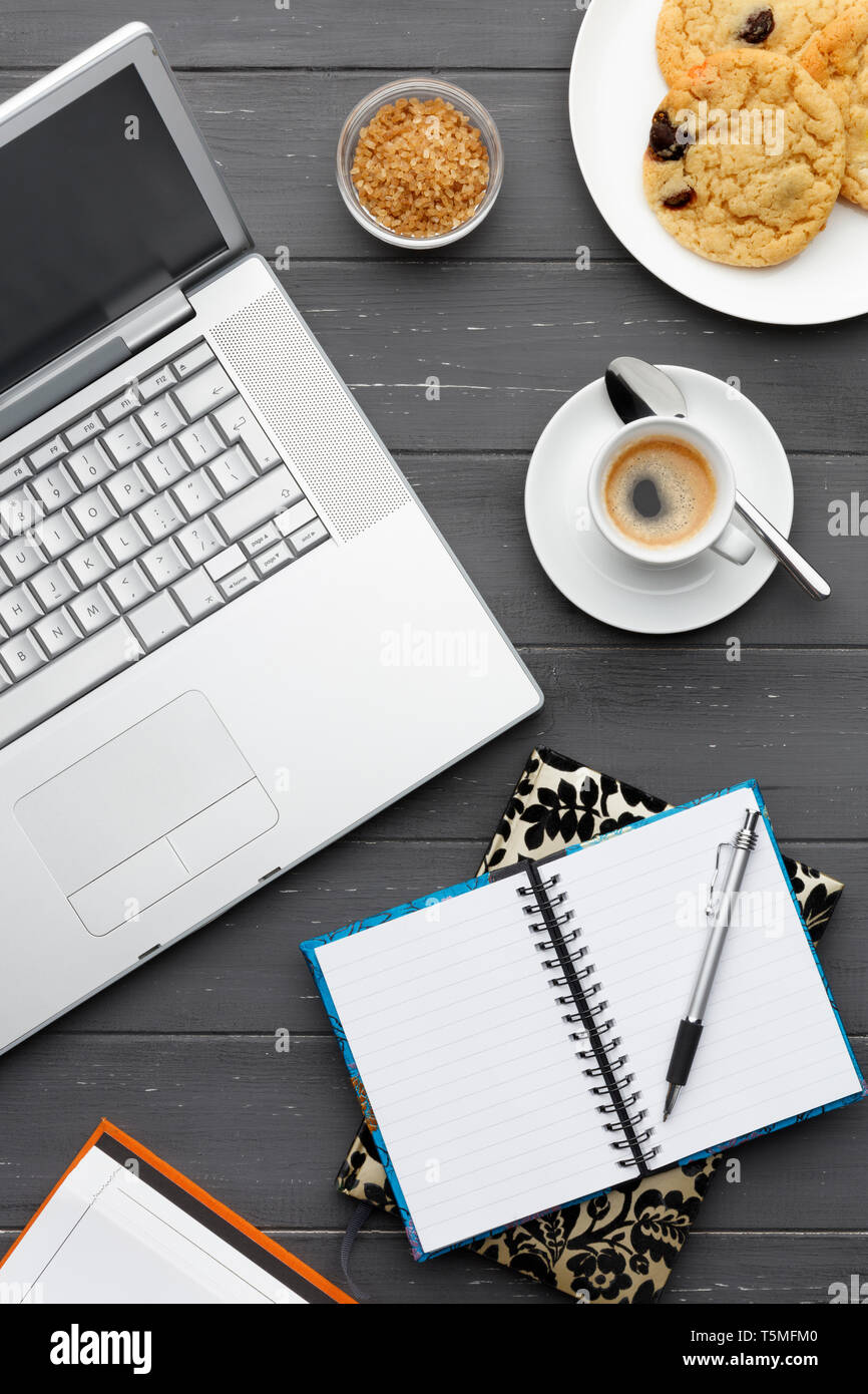 portrait view of a working coffee break with laptop, coffee, cookies ...