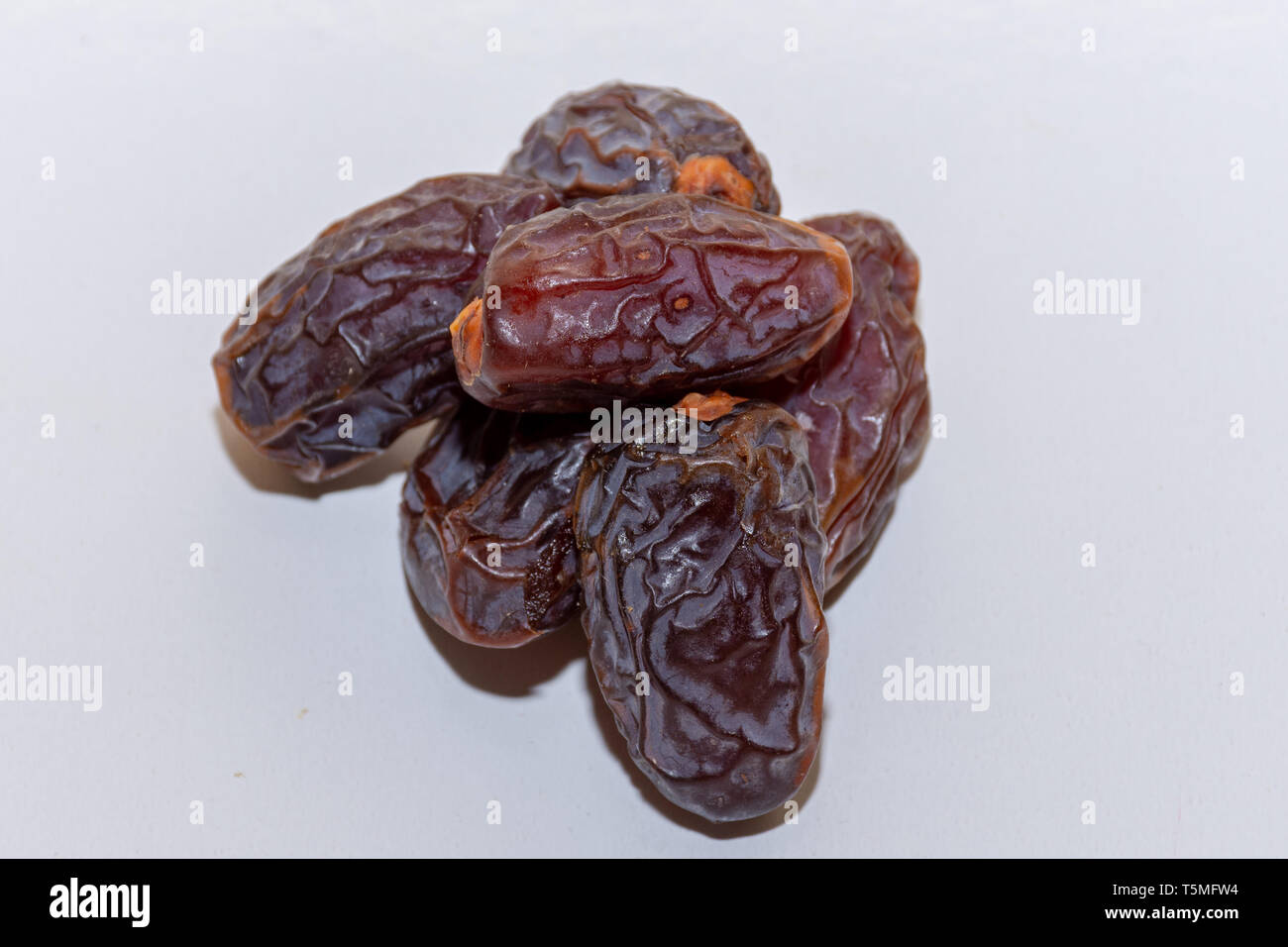 A group of madjool dates from Saudi Arabia on a white background for ...