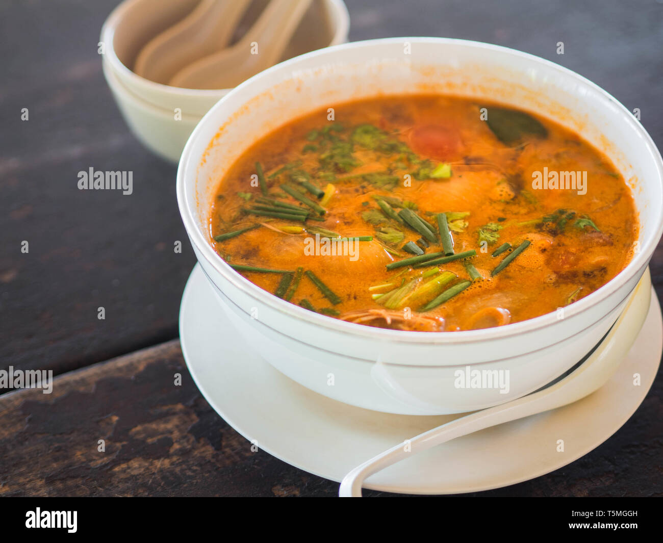 Sour and spicy Tom Yum Goong soup on a table in a restaurant. Thai ...