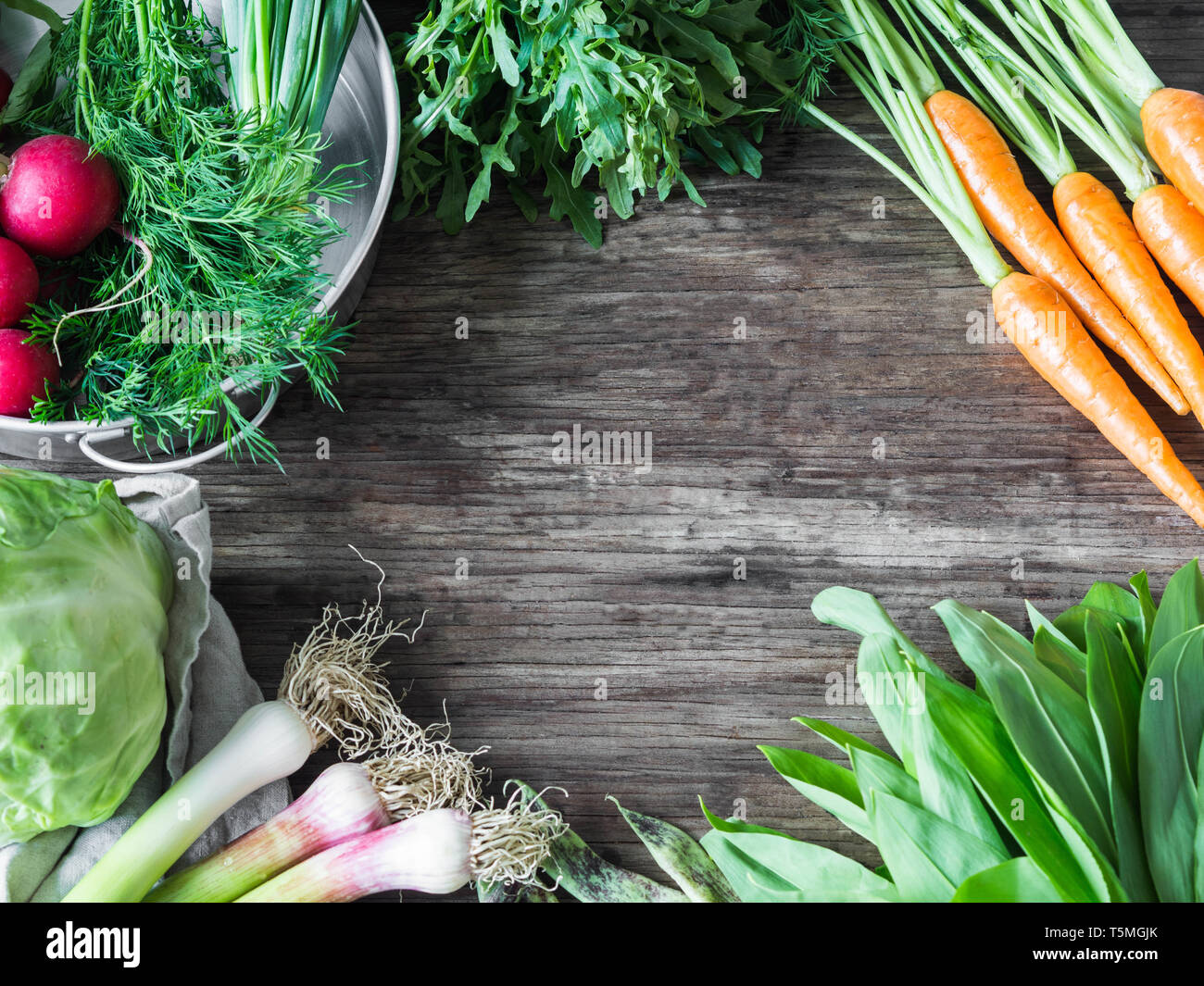 Fresh Spring vegetables and herbs frame on rustic wood background ...