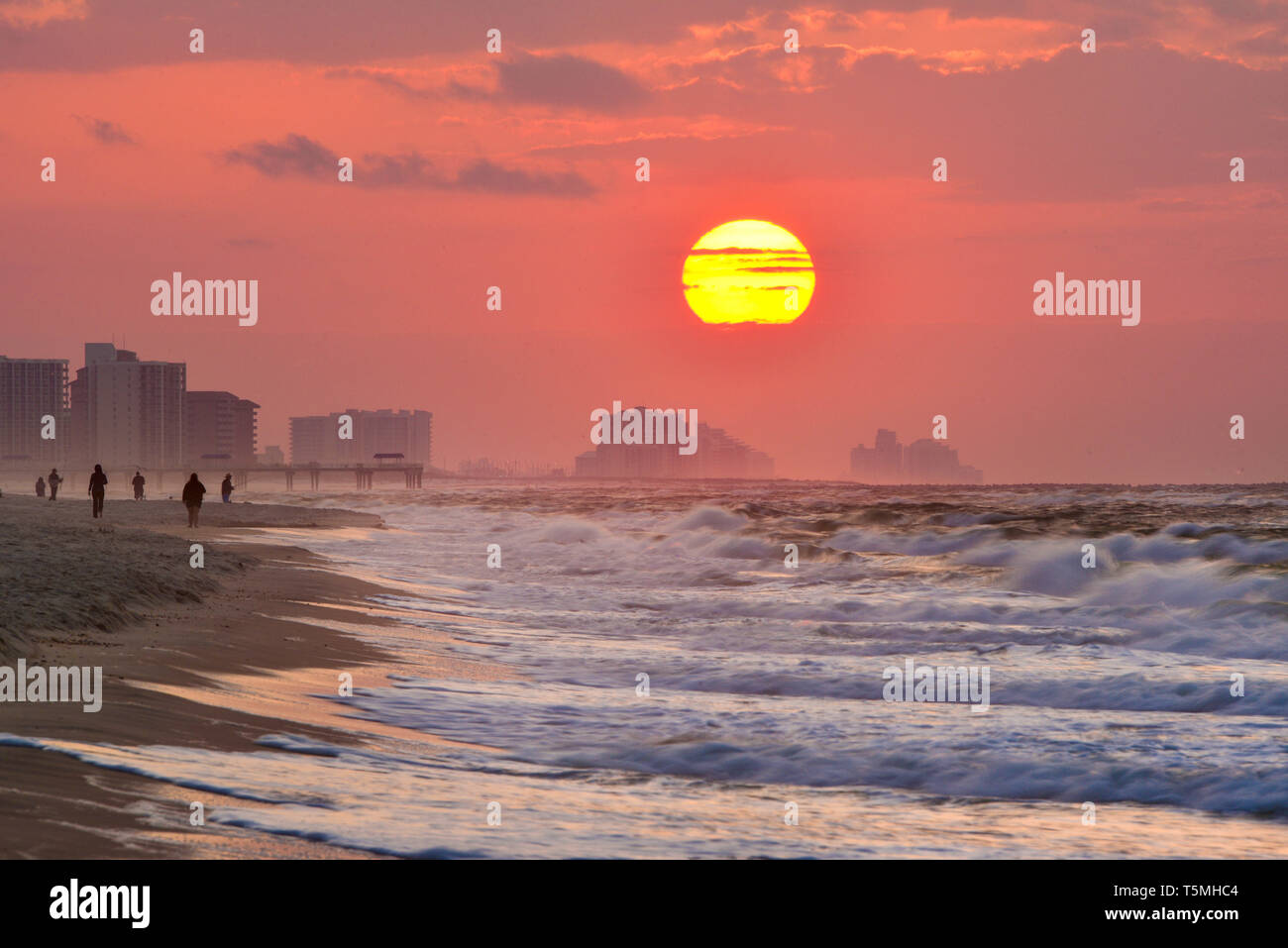 Bright sunrise, with clouds, along beach over Atlantic Ocean with waves ...