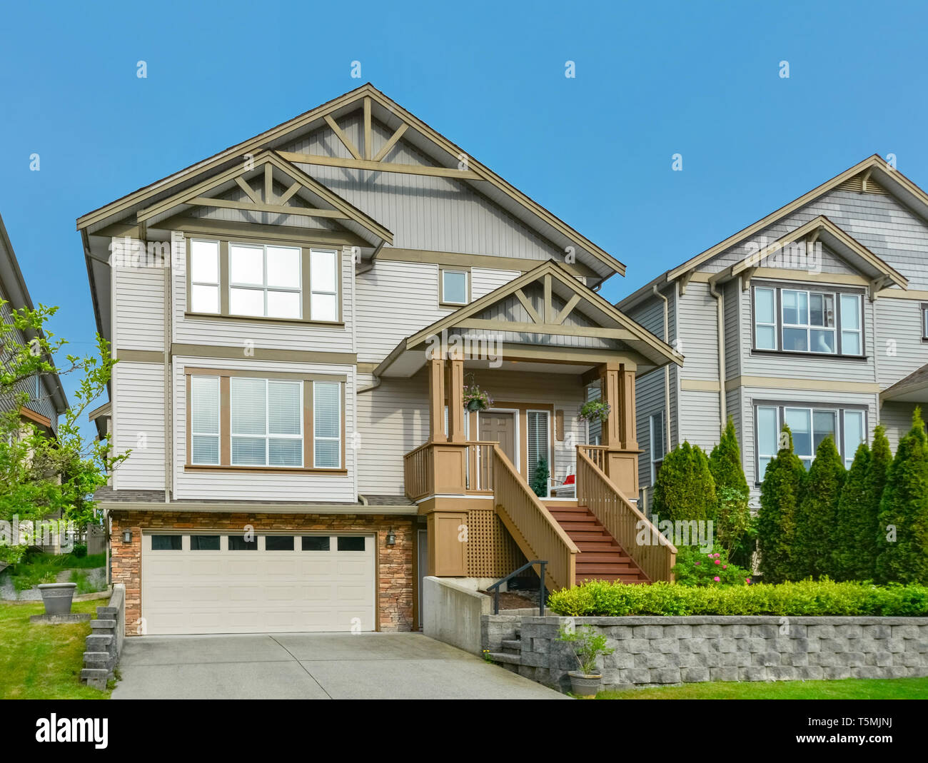 Main entrance of residential house with concrete driveway and small ...