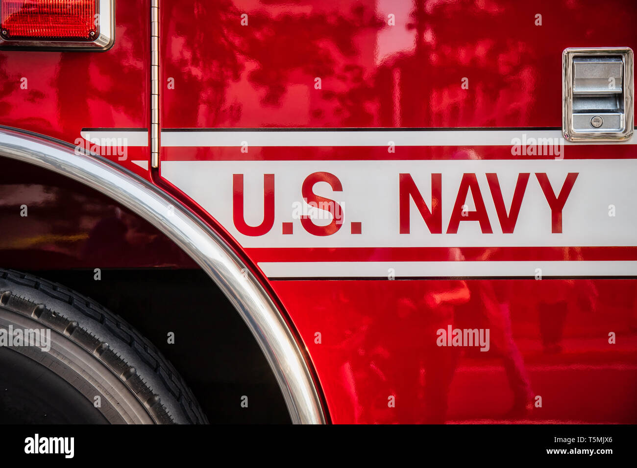 A crowd reflects on the door of a US Navy fire truck on display at ...