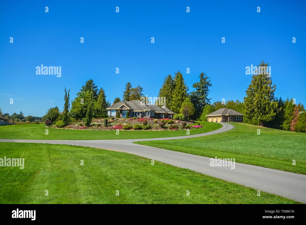 Asphalt road junction running over landscape with big farmer's house on ...