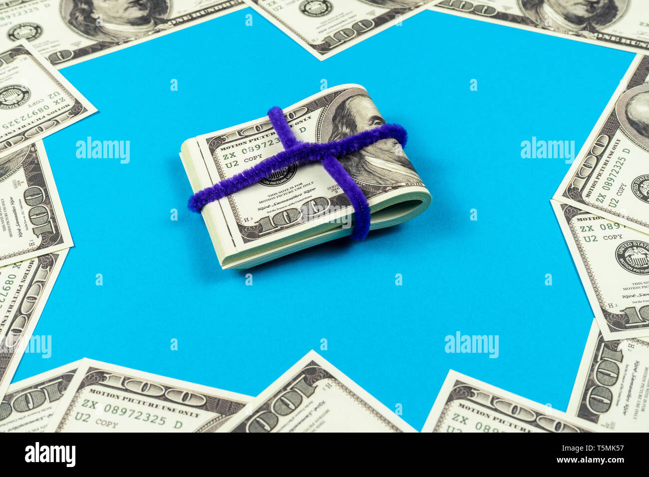 Dollar bills folded in half on light blue background Stock Photo - Alamy