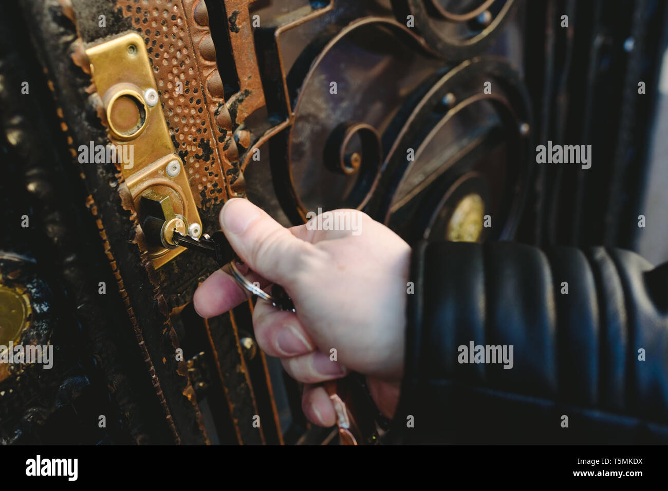 Man's hands trying to open a door by inserting the key into the lock ...