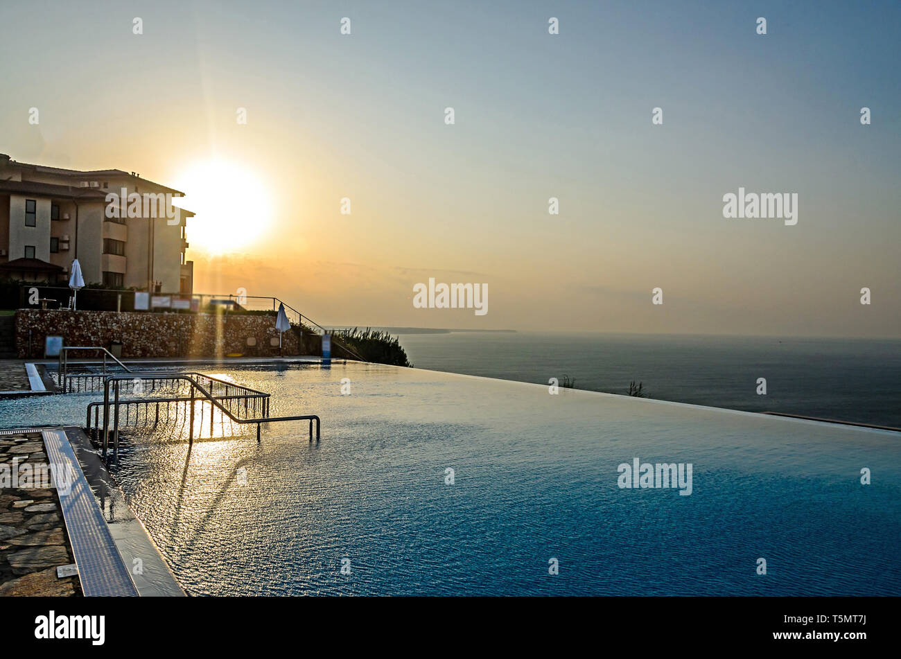 Infinity pool with crystal blue water view to sea ocean Stock Photo - Alamy