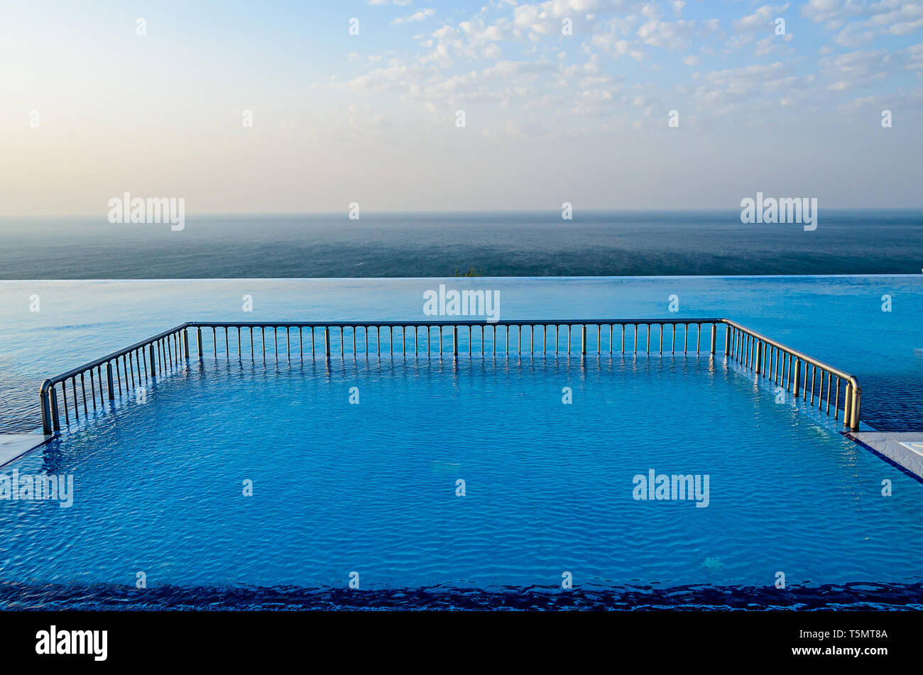 Infinity pool with crystal blue water view to sea ocean Stock Photo - Alamy