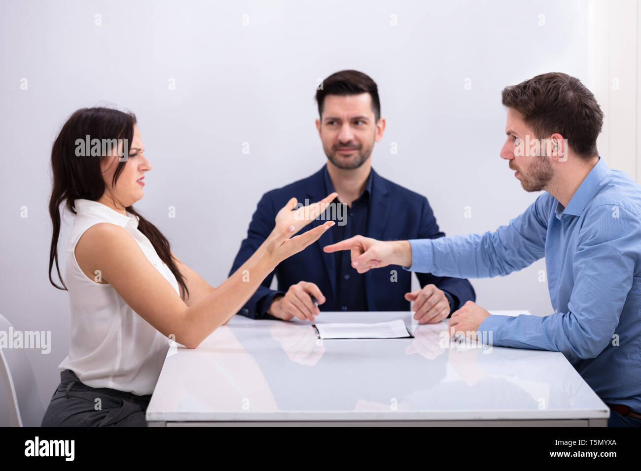 Young Couple Arguing With Each Other In Front Of Judge At Courtroom ...