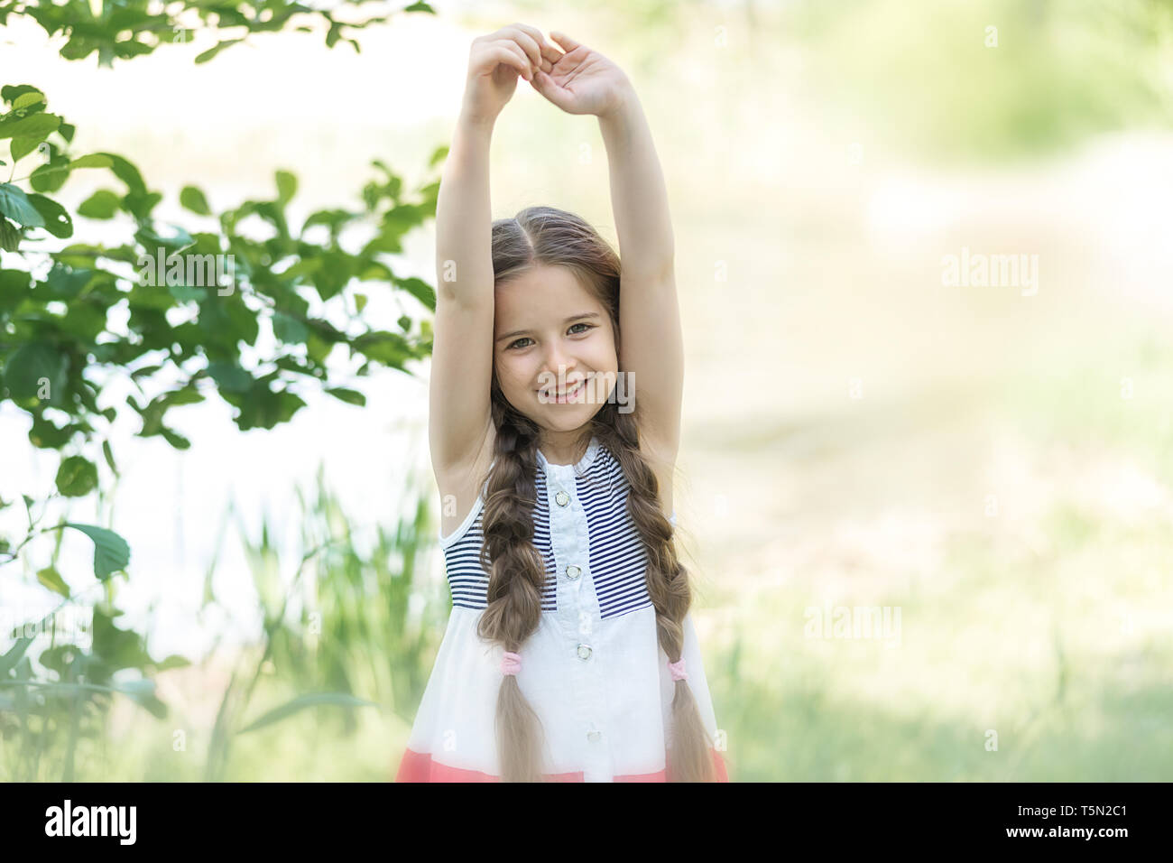 Portrait of a happy little girl on nature background Stock Photo - Alamy