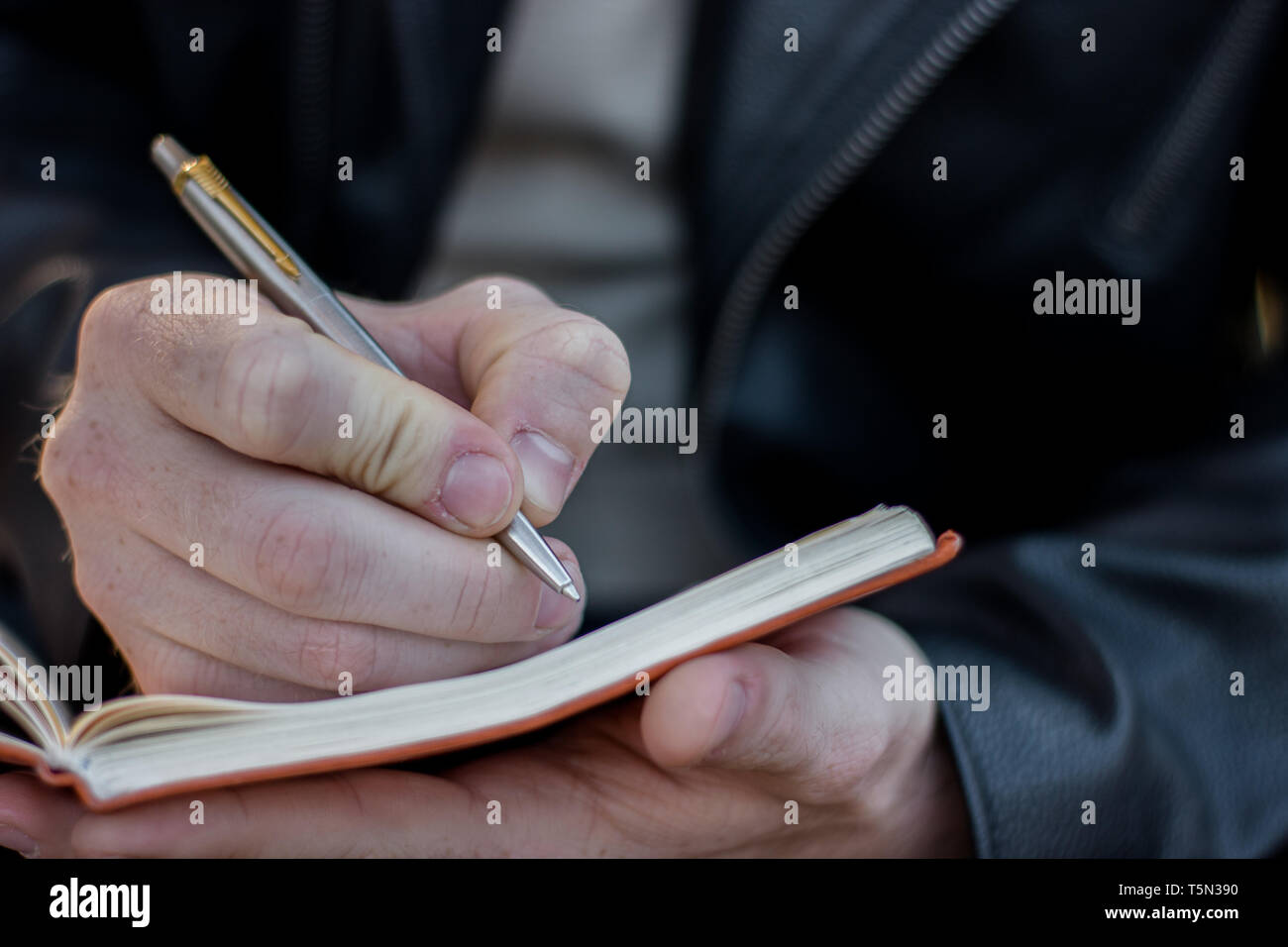 Guy creator in casual clothes makes notes in a notebook Stock Photo - Alamy