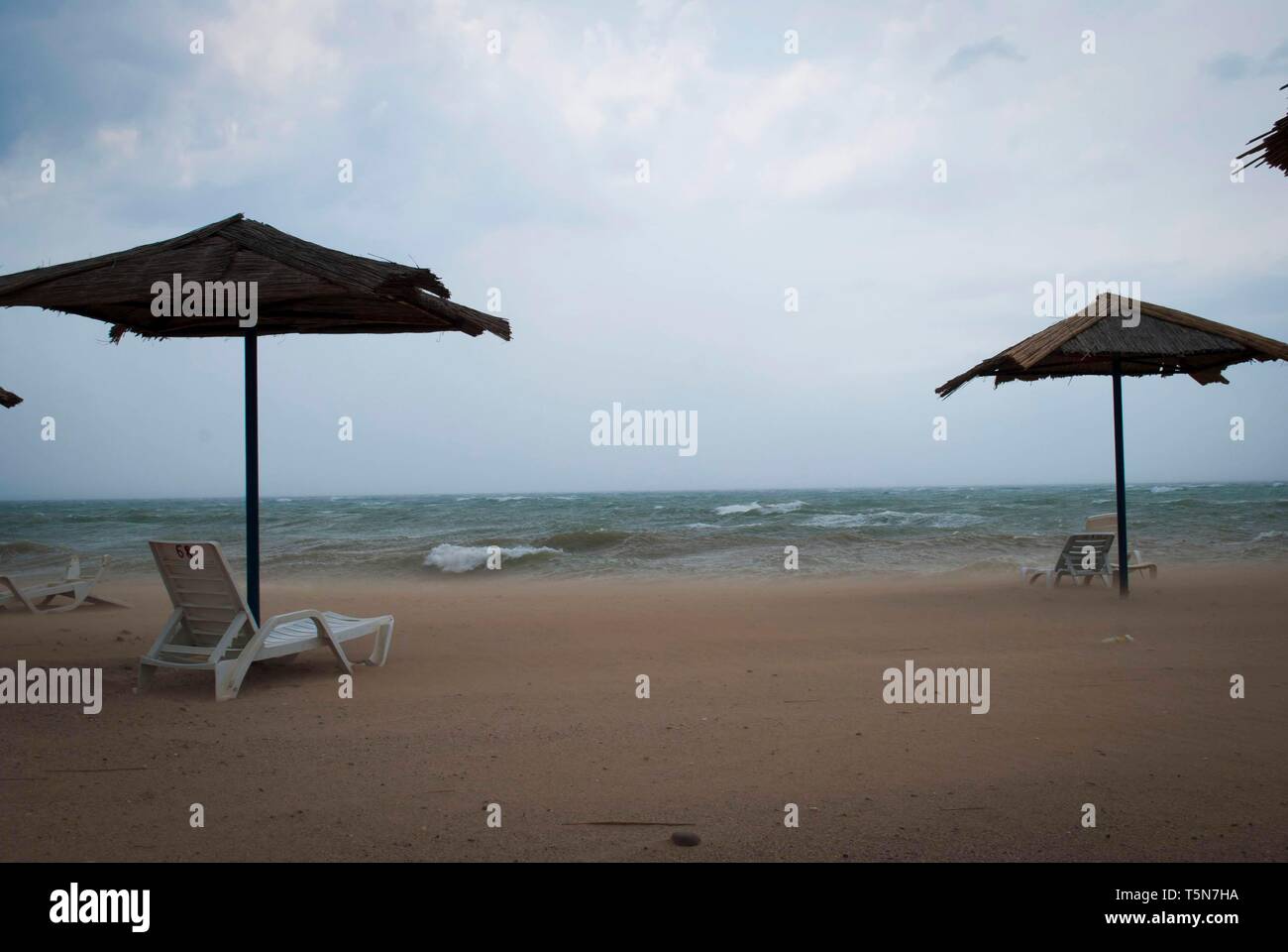 Storm on the sea with thunderclouds. Beach umbrellas and sun beds on ...