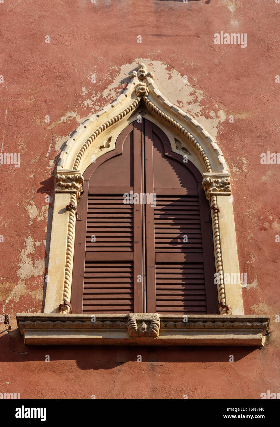 Old arched window with wooden shutters of medieval house in Verona ...