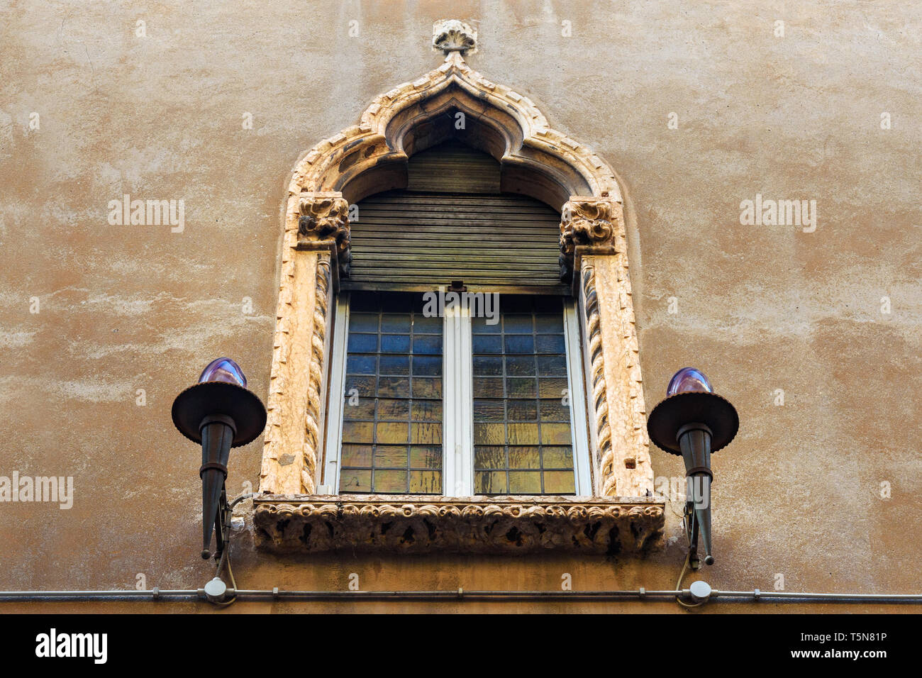 Old arched window with wooden shutters of medieval house in Verona ...