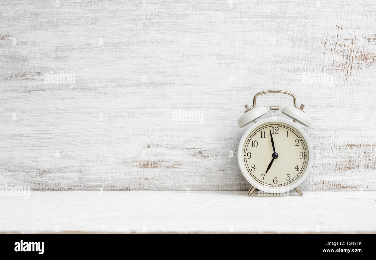 Vintage classic white alarm clock on white grunge background with free ...
