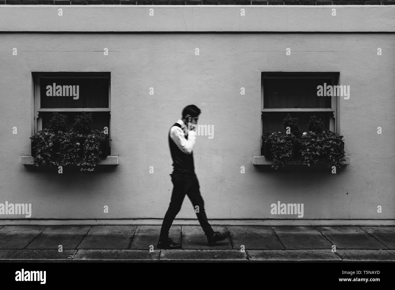 Waiter walking and deep in conversation Stock Photo - Alamy