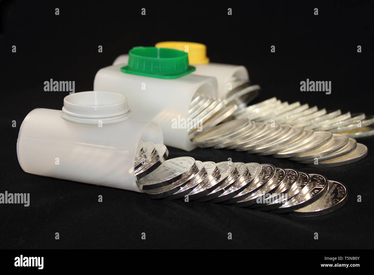 Three tubes with silver coins Stock Photo - Alamy