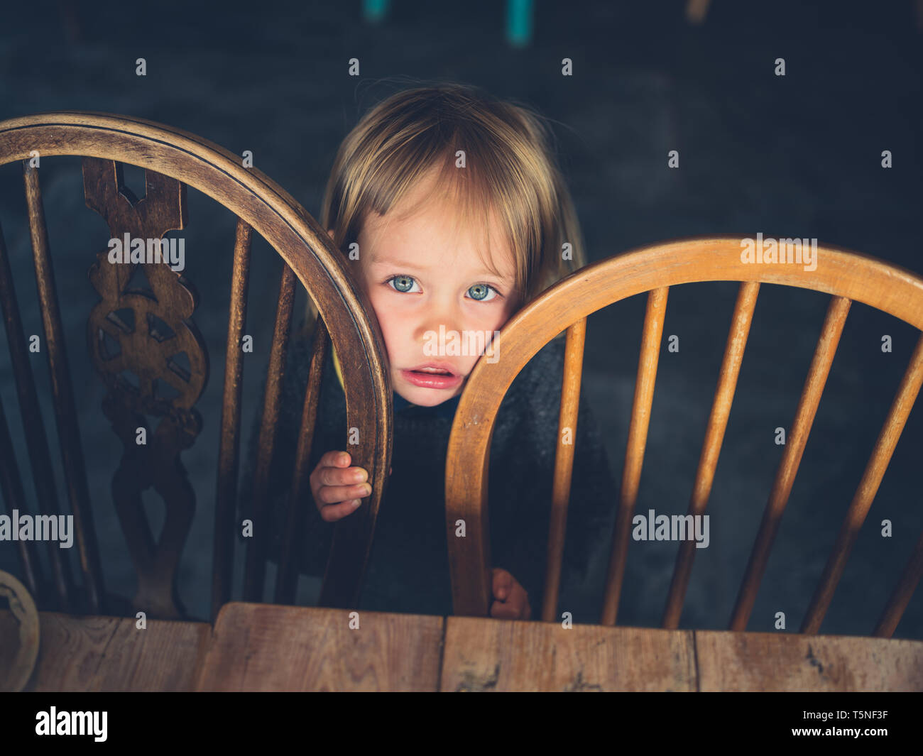 Hiding behind chair hi-res stock photography and images - Alamy