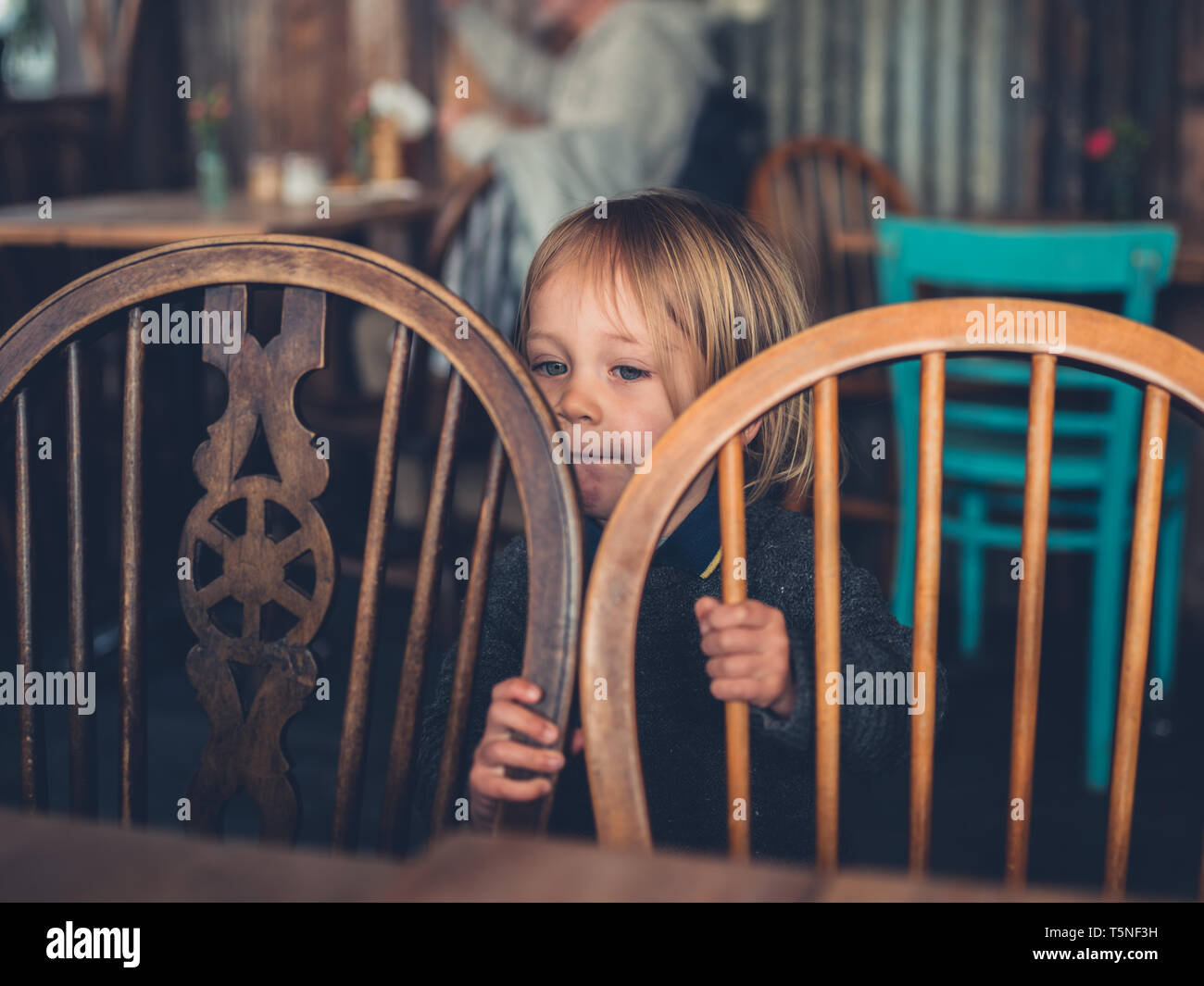 Hiding behind chair hi-res stock photography and images - Alamy