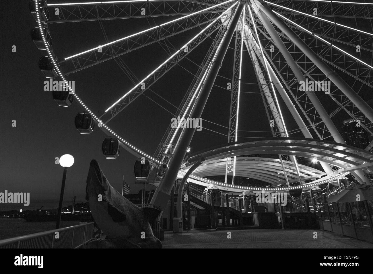 An illuminating Ferris wheel ride on the waterfront pier where the ...