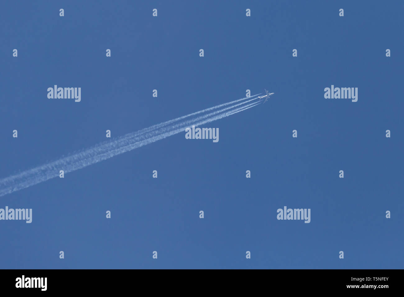 plane flying in a blue sky Stock Photo - Alamy