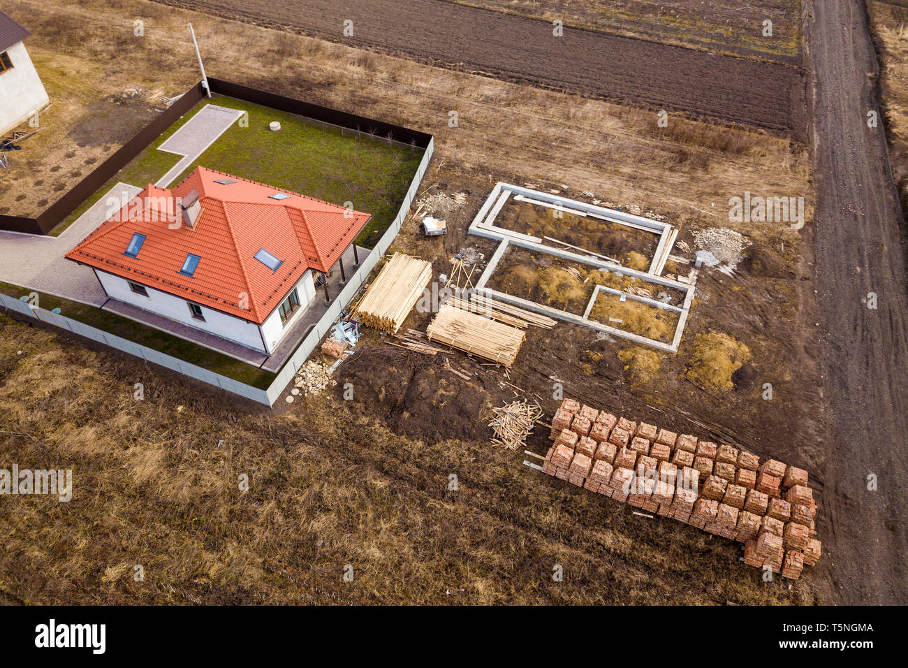 Aerial view of new house roof with attic windows and building site ...