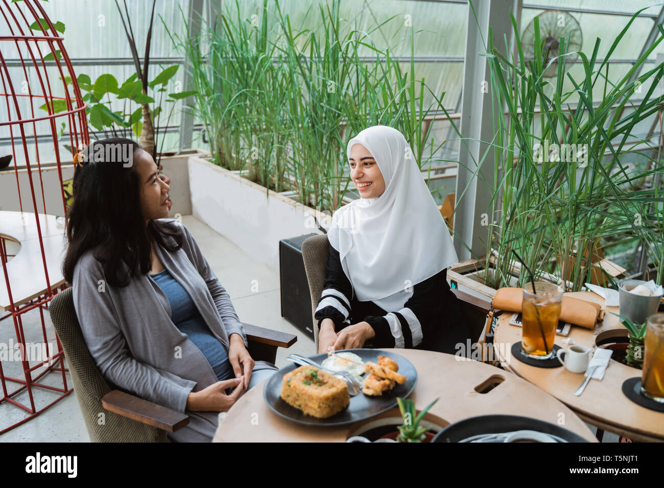 muslim woman talking in cafe together Stock Photo - Alamy