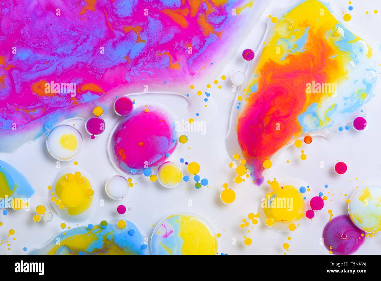 Colorful paint drops mixed in liquid on white background Stock Photo ...