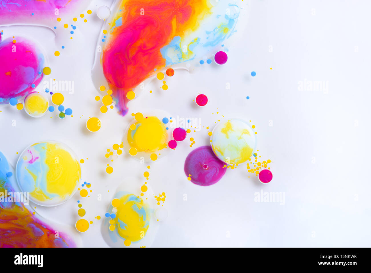 Colorful paint drops mixed in liquid on white background Stock Photo ...