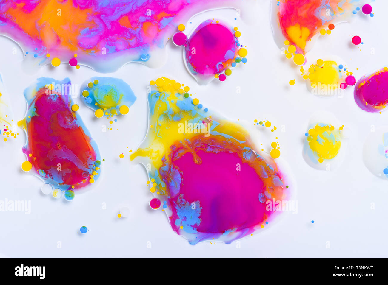 Colorful paint drops mixed in liquid on white background Stock Photo ...
