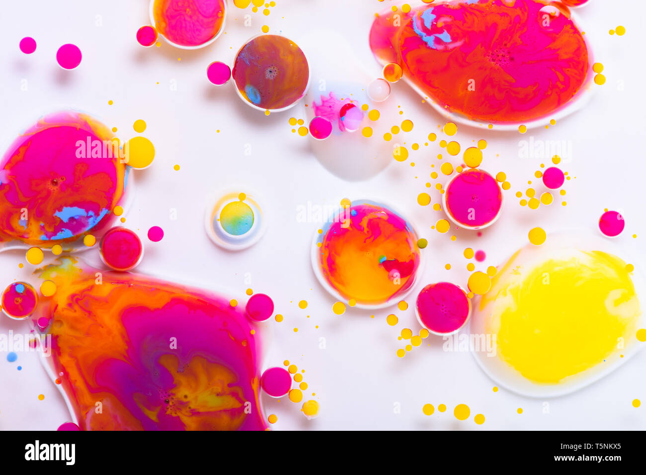 Colorful paint drops mixed in liquid on white background Stock Photo ...