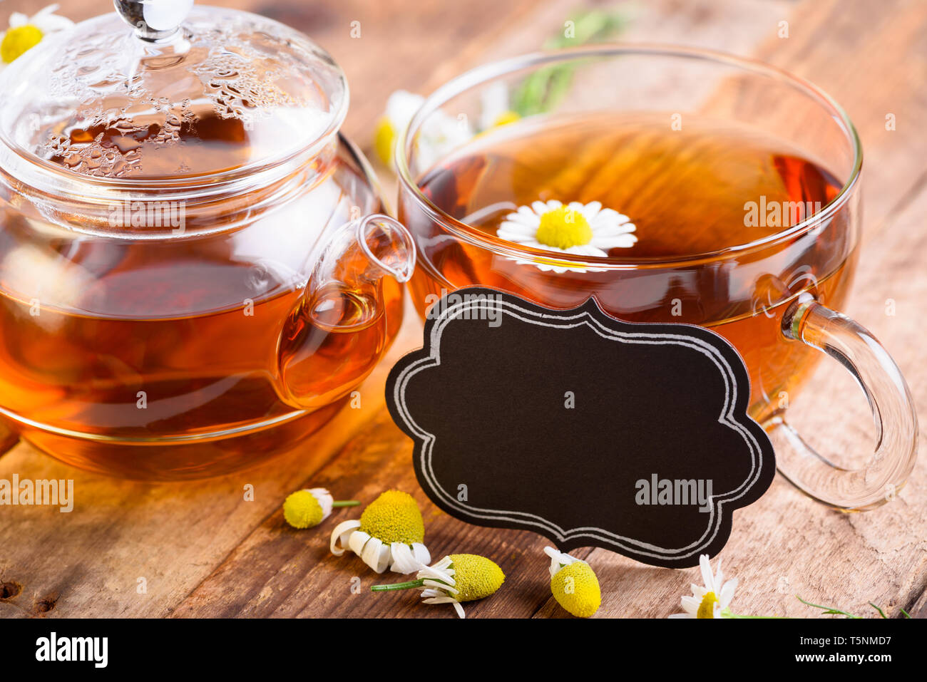 Herbal tea with chamomile flowers and blank label on wooden table Stock ...