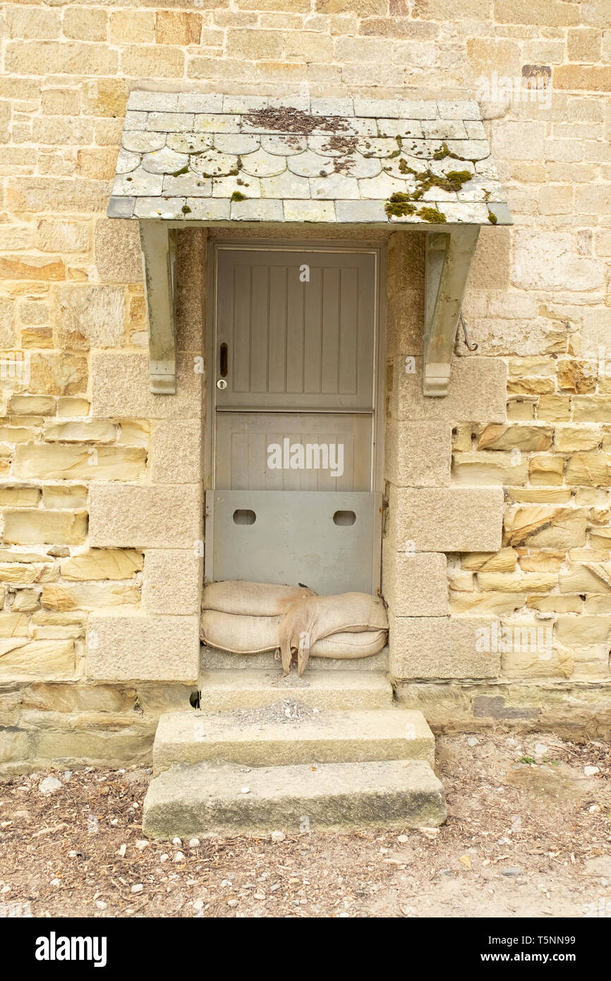 Door with sandbags and weathering on beach house wall made of granite ...