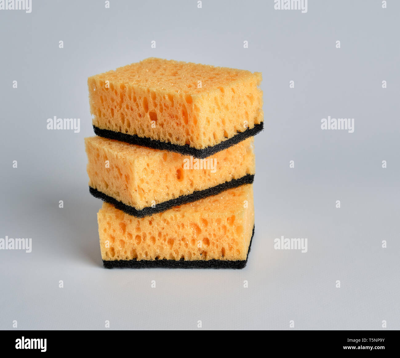 stack of yellow kitchen sponges for washing dishes on a white ...