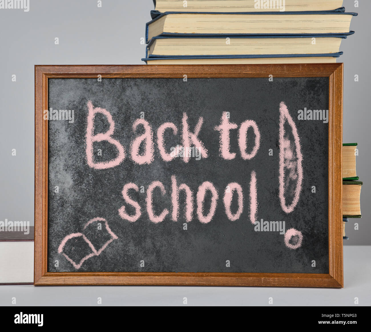 black chalk drawing frame and stack of books, gray background , back to ...