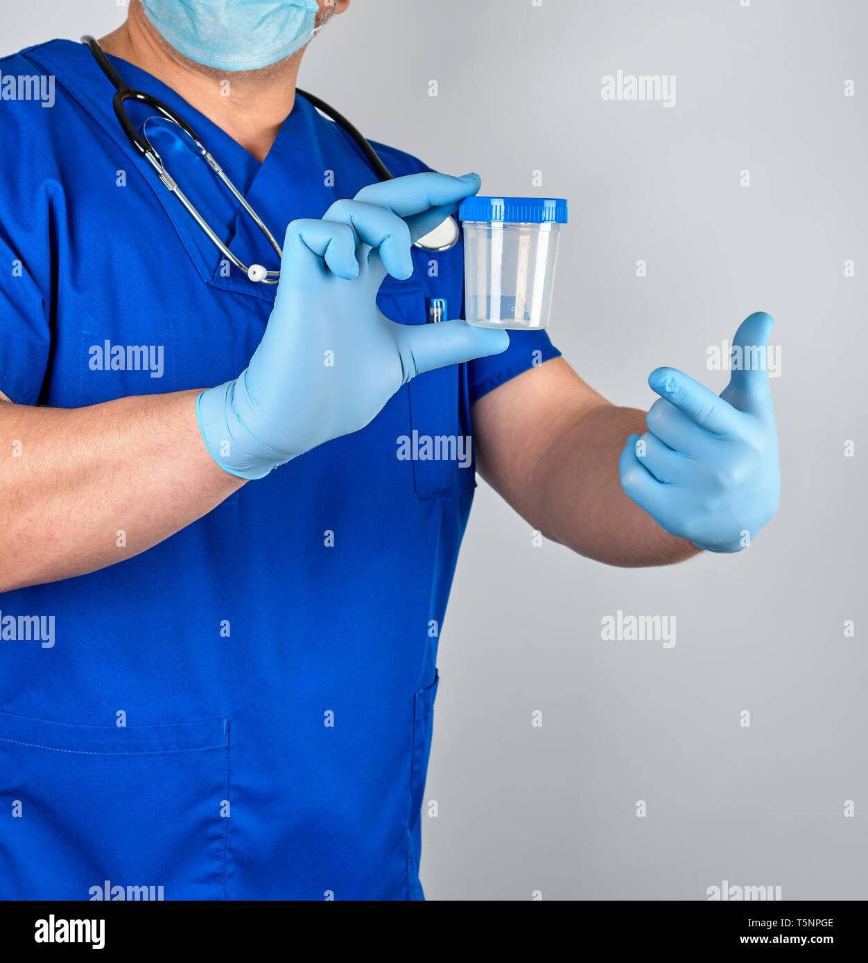 doctor in blue uniform and latex gloves is holding an empty plastic ...