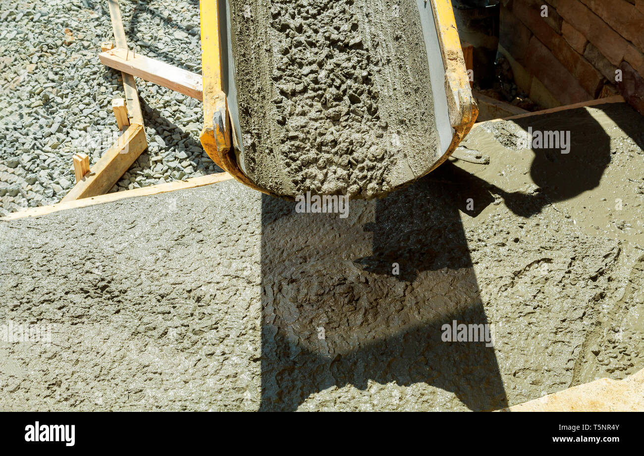 Construction of a concrete walkway around a residential rural house in ...