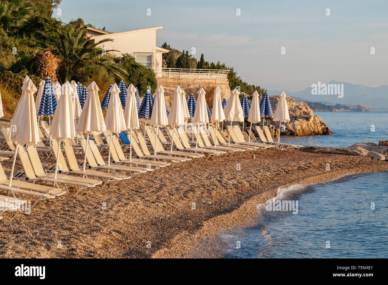 Summer sunrise on coast, Corfu island, Greece. Beach with Sunbeds and ...