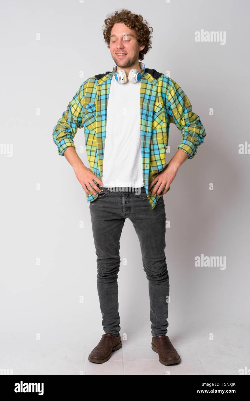 Full body shot of happy handsome hipster man thinking and looking down ...