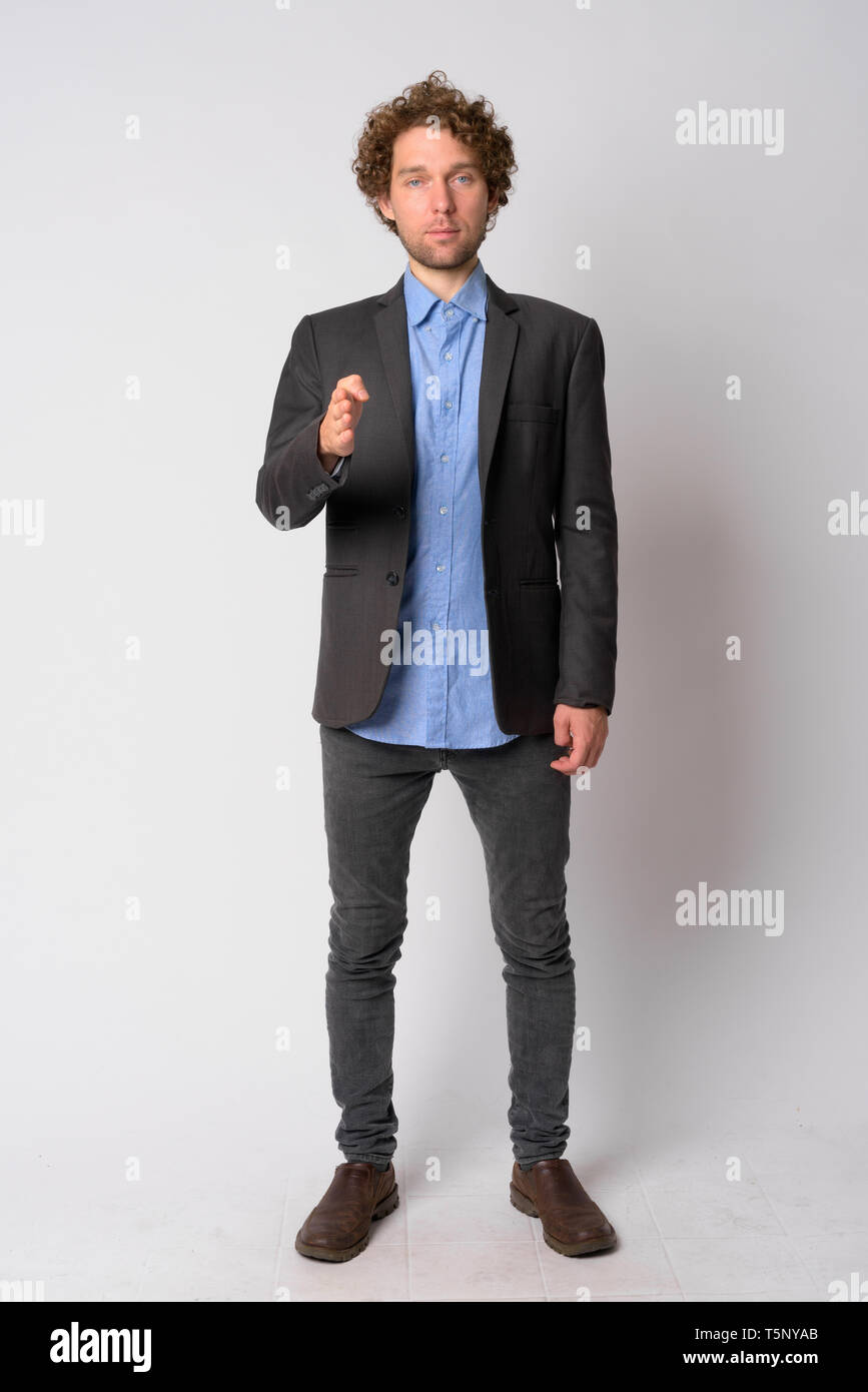 Full body shot of handsome businessman with curly hair giving handshake ...
