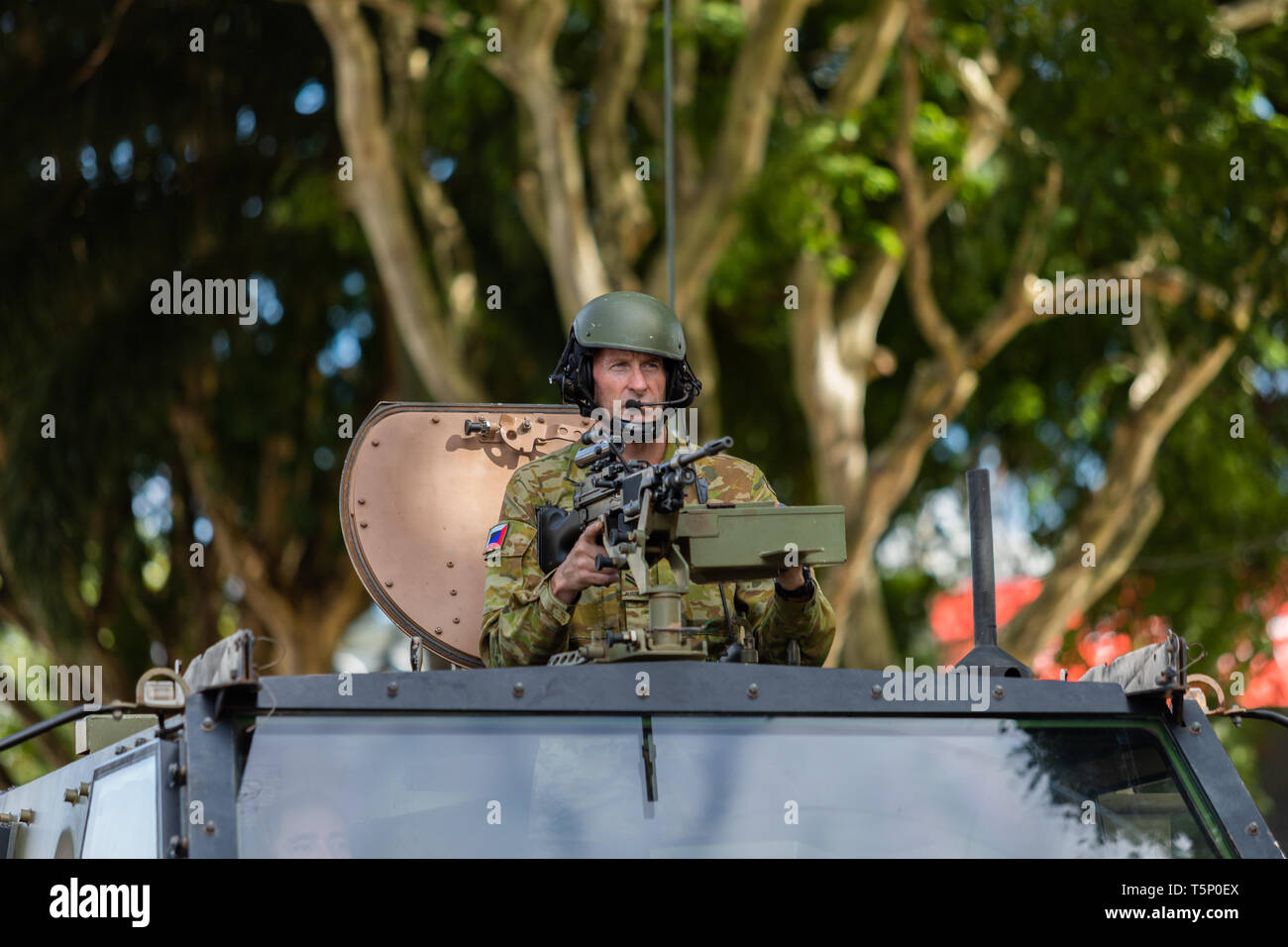 A stern faced army officer manning the gun at the hatch of his army ...