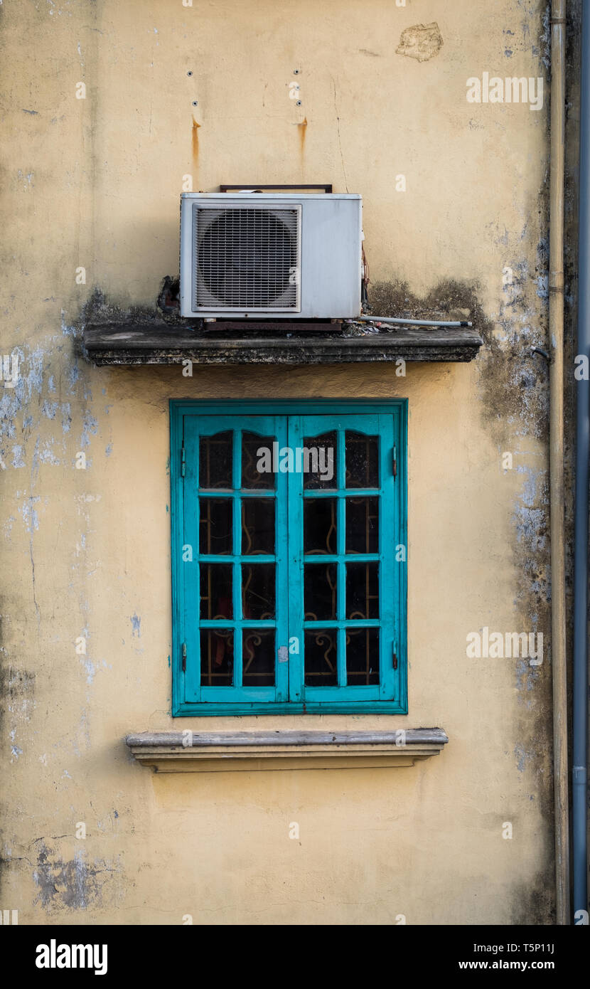 Old green window with air compressor on decay yellow wall Stock Photo ...