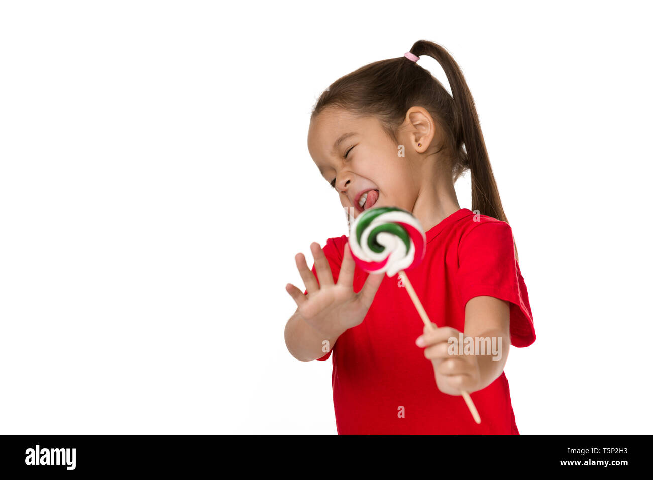 cute little girl with candy lollipop doing stop sign isolated on white ...