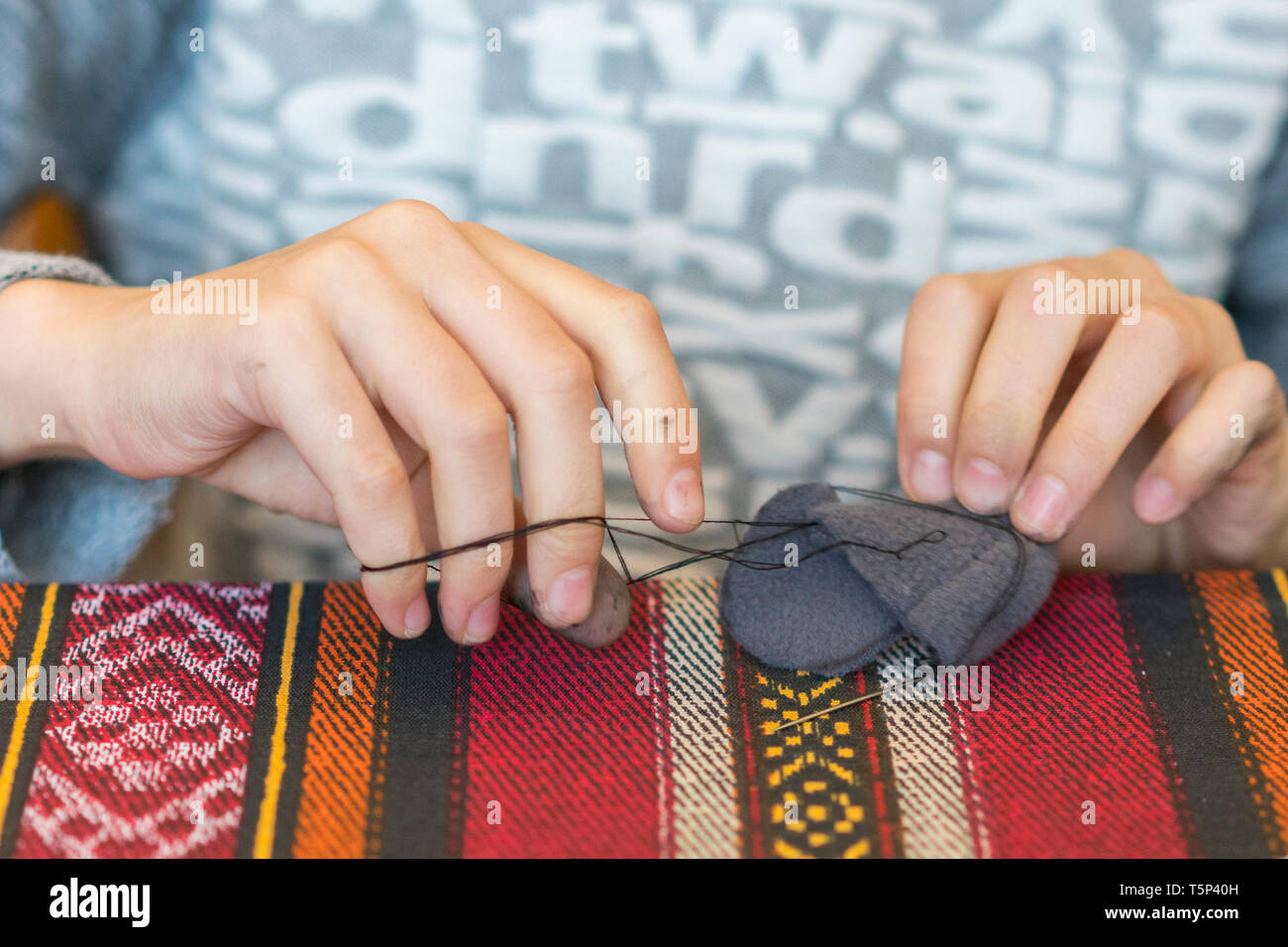 Little girl with a needle and thread. creation. little girl sews toy ...