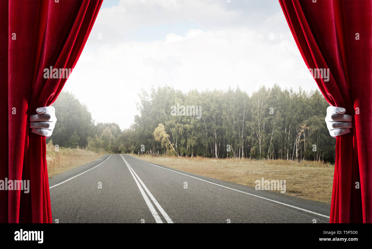 Asphalt road behind red curtain and hand holding it Stock Photo - Alamy