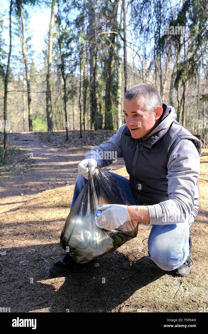 A man collects garbage. Puts it in a garbage bag. The problem of ...