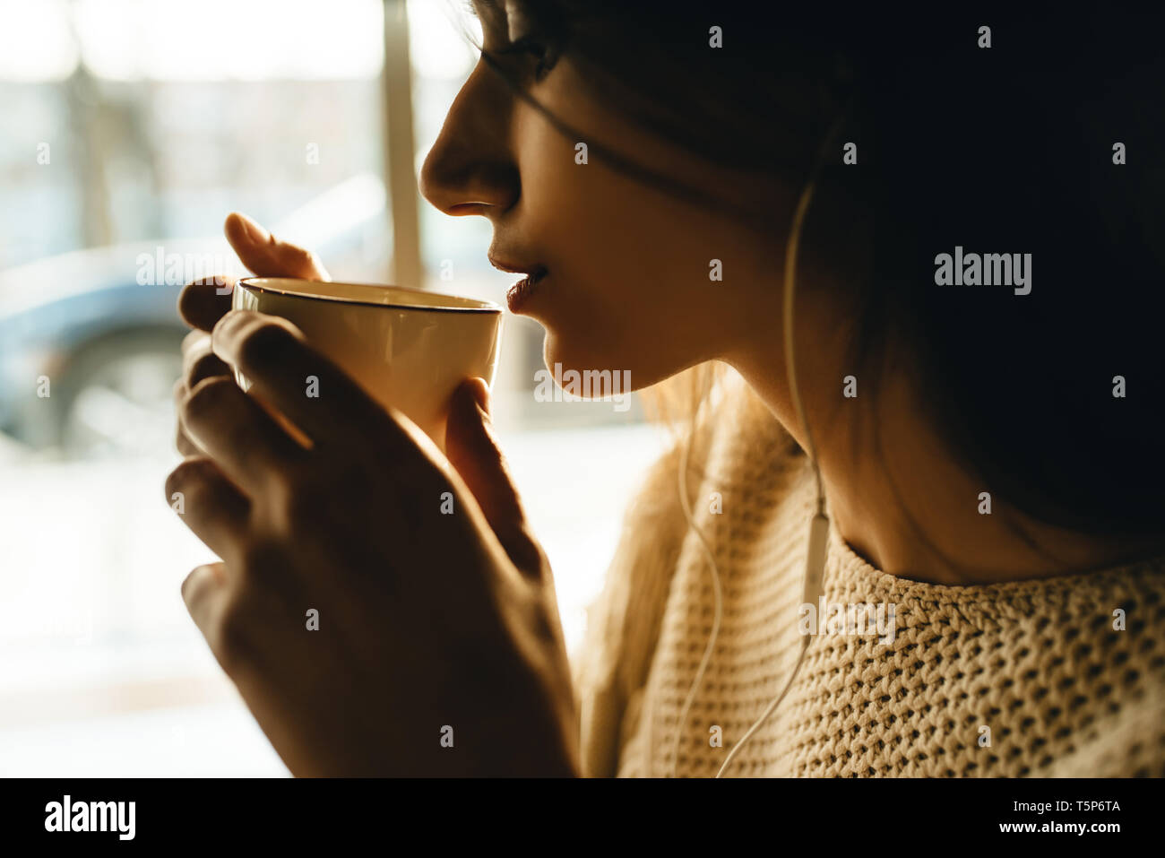 Beautiful girl drinking coffee in a cafe and listening to music Stock ...