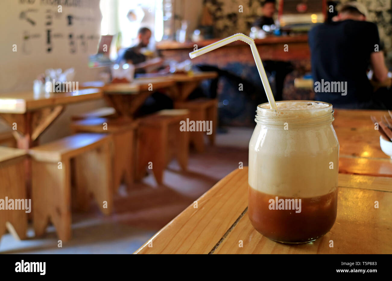 Iced cappuccino coffee on the cafe's wooden table Stock Photo - Alamy